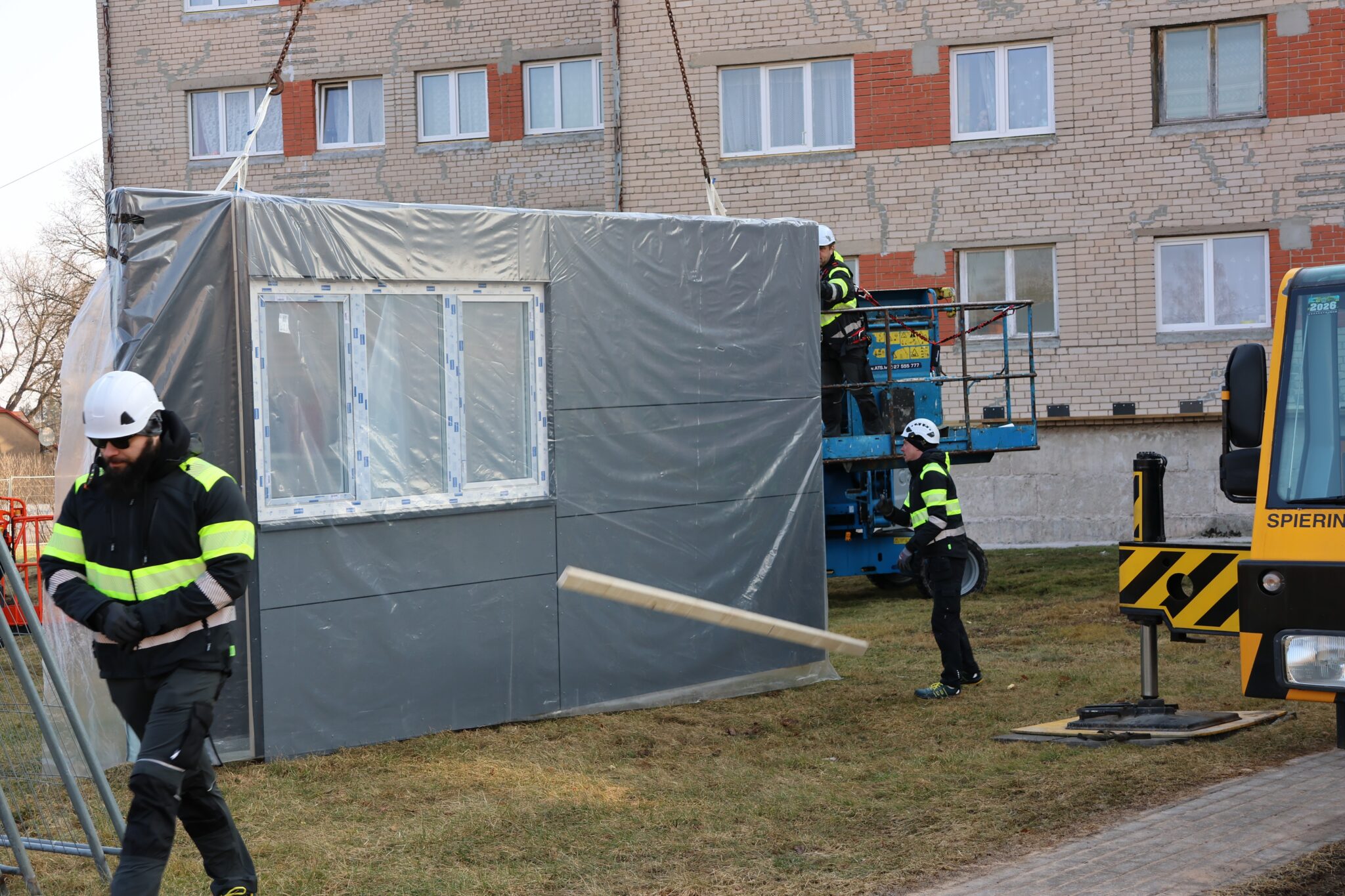 Daudzdzīvokļu mājas fasāde tiek pie pirmajiem rūpnieciski ražotiem koka ...